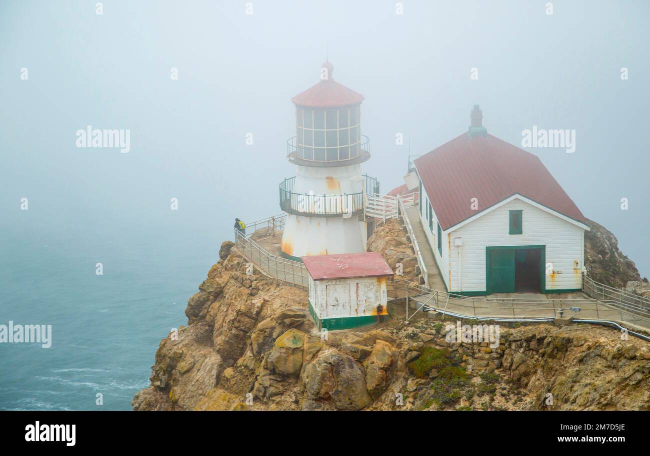 The Point Reyes Lighthouse covered in the fog surrounded by the sea in ...