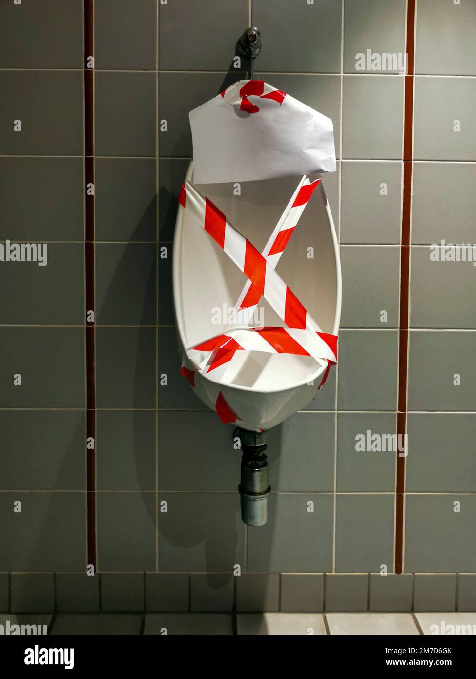A vertical shot of a urinal for men with a barricade tape Stock Photo ...