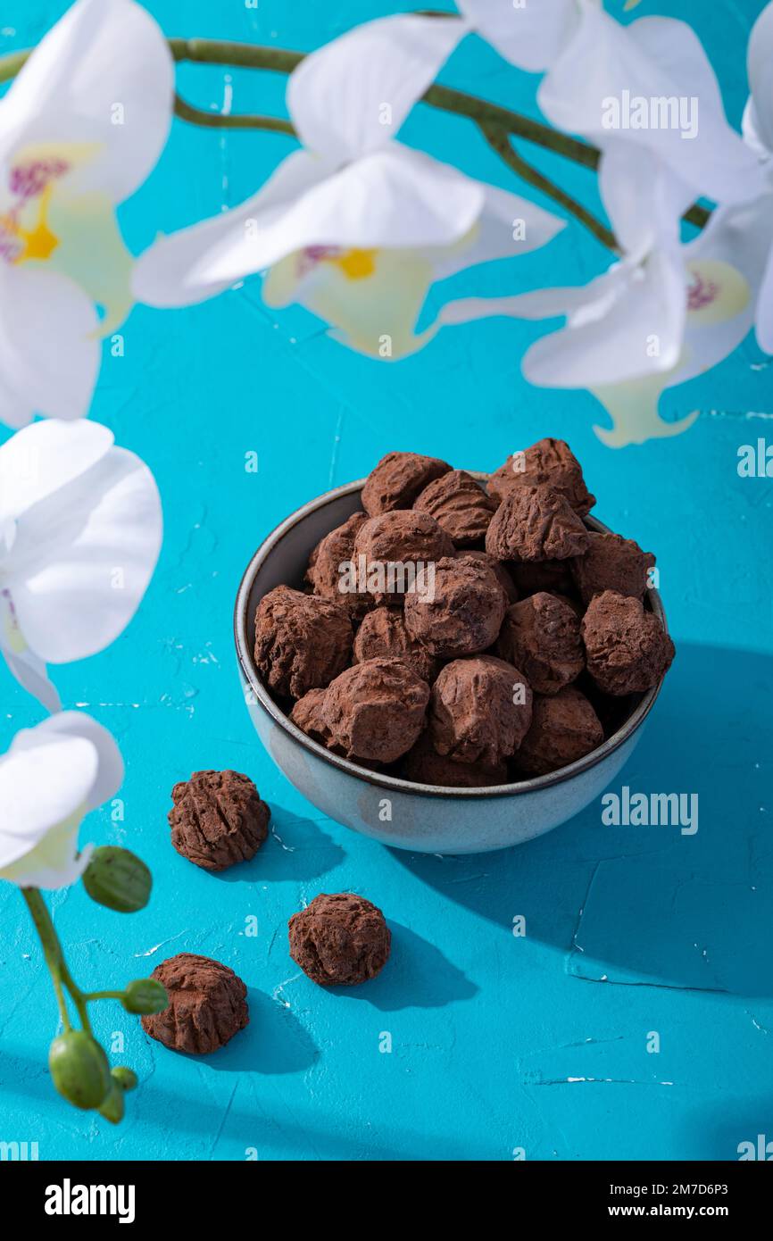 Handmade rustic chocolate truffles with white orchid flowers on ...