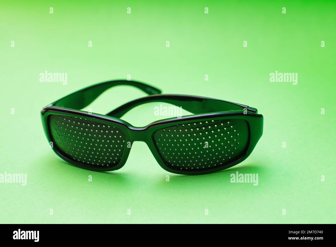 Perforated visual exercise glasses on a green background Stock Photo ...