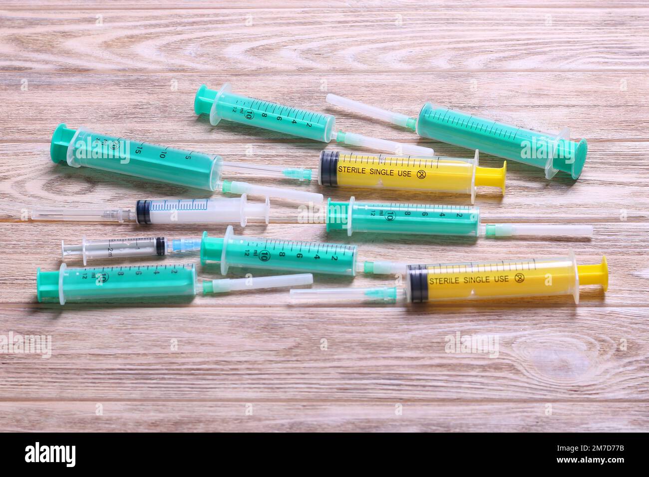 Top view of many syringes prepared for injection at wooden background ...