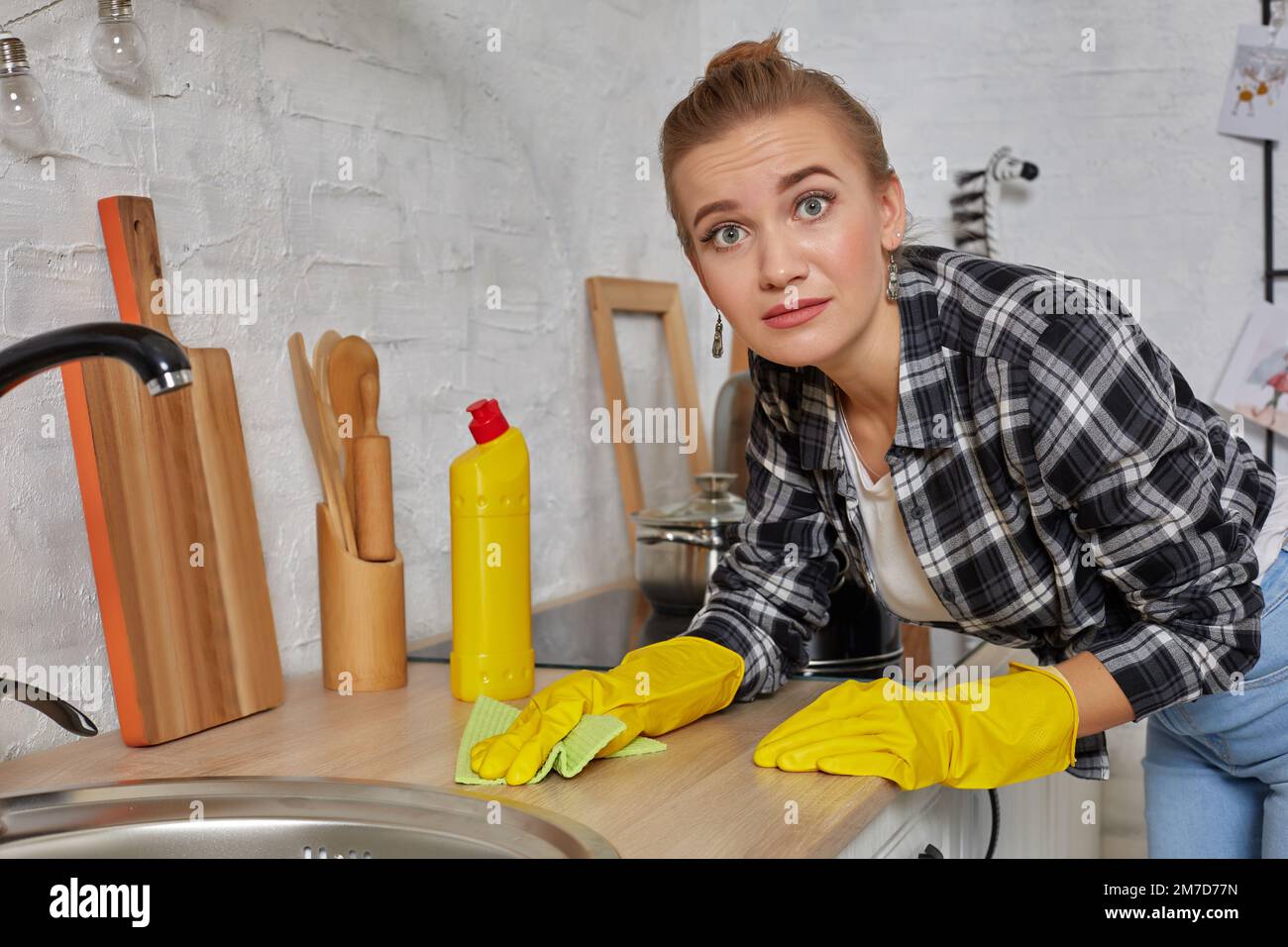 Young woman washing manually, by hand, wearing yellow cleaning rubber ...