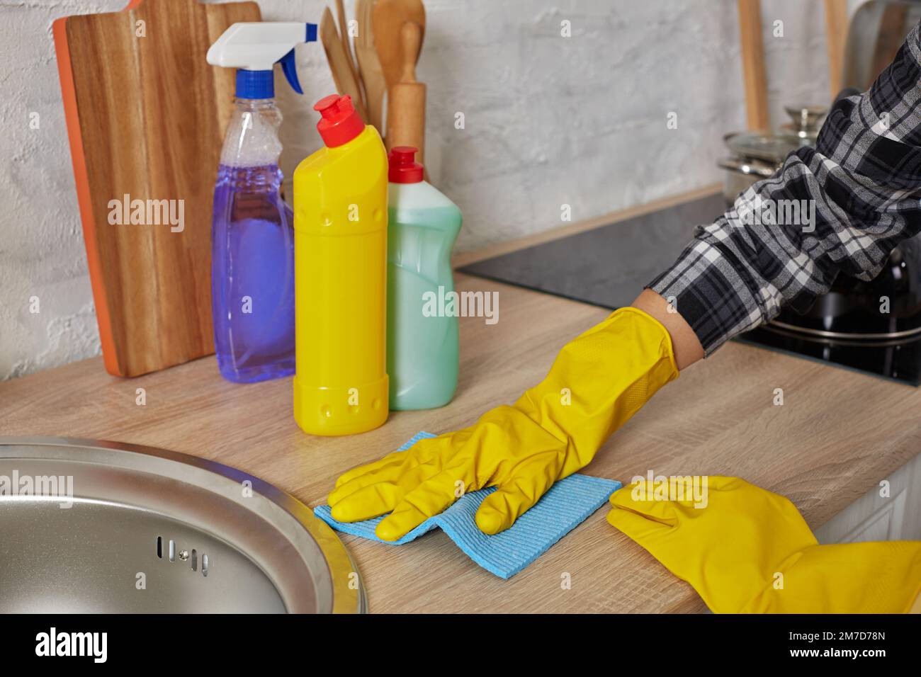 Hands in gloves with green rag is cleaning kitchen cabinets - housework ...