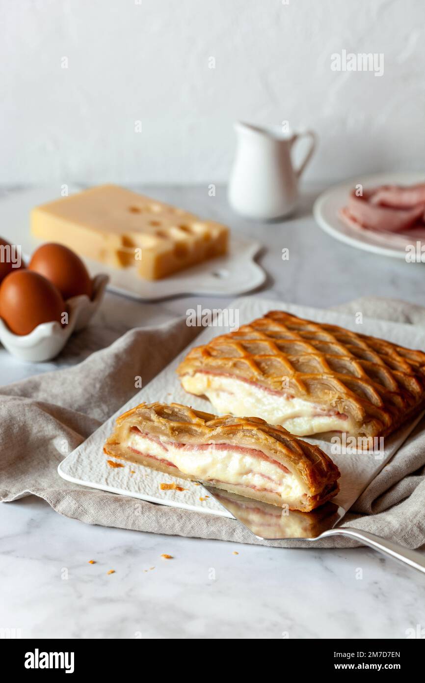puff with ham and cheese cut on a rectangular plate on a kitchen table ...