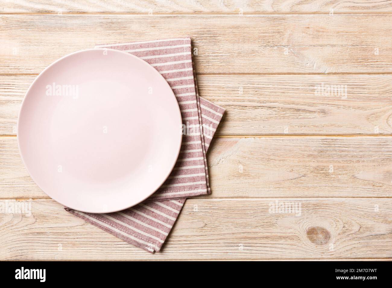 Top view on colored background empty round pink plate on tablecloth for ...