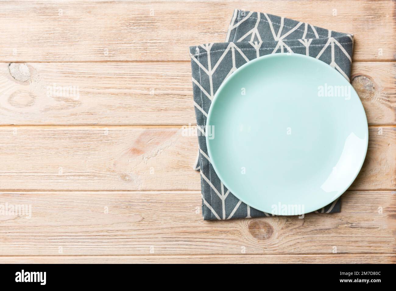 Top view on colored background empty round Blue plate on tablecloth for ...