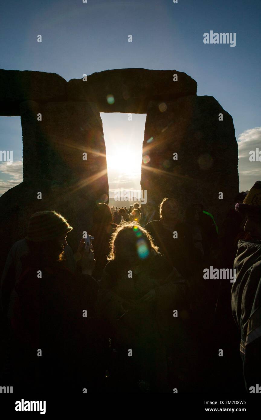 The sun can be seen rising behind the ancient stones at Stonehenge ...