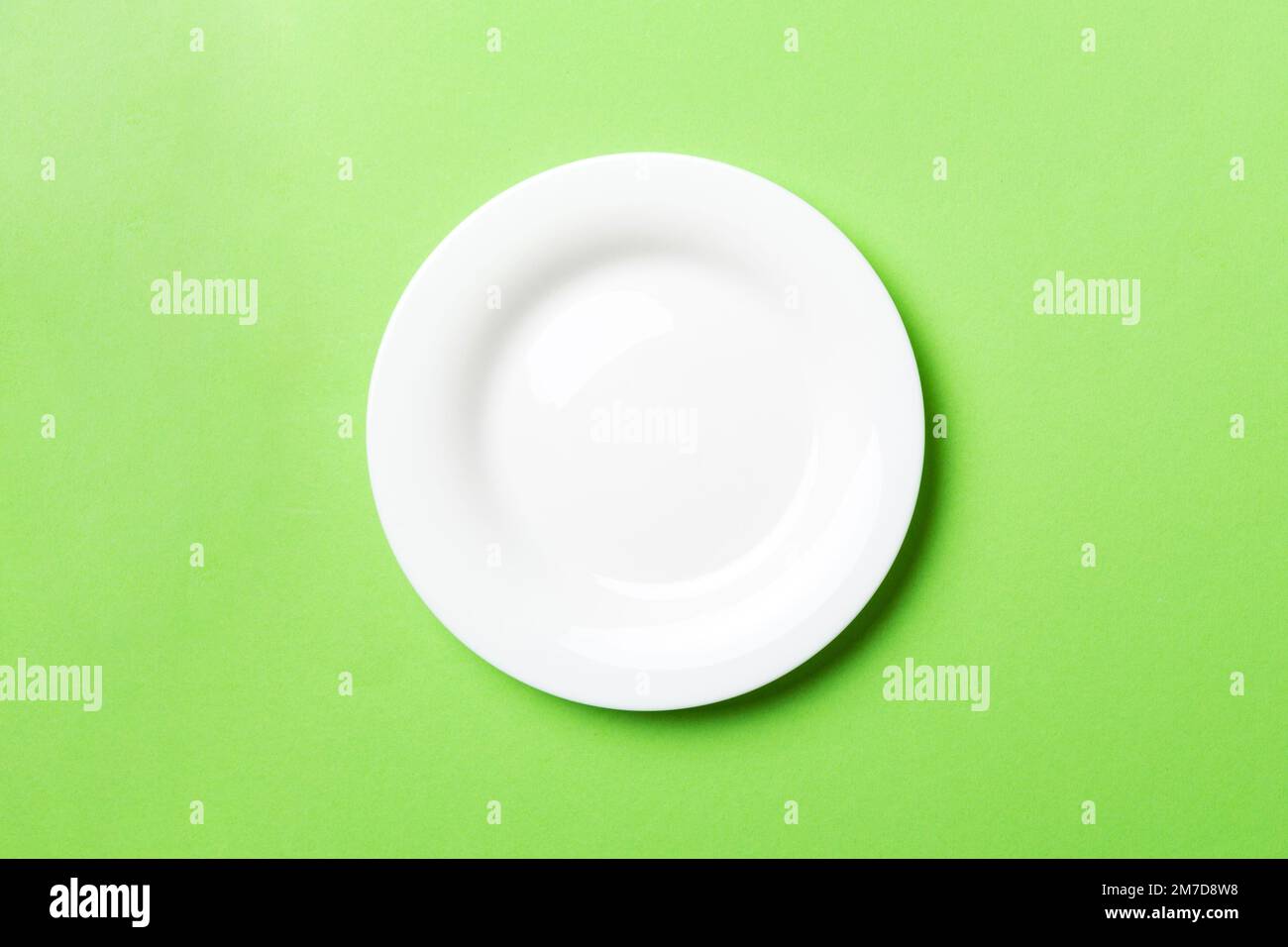 Top view of isolated of colored background empty round white plate for ...