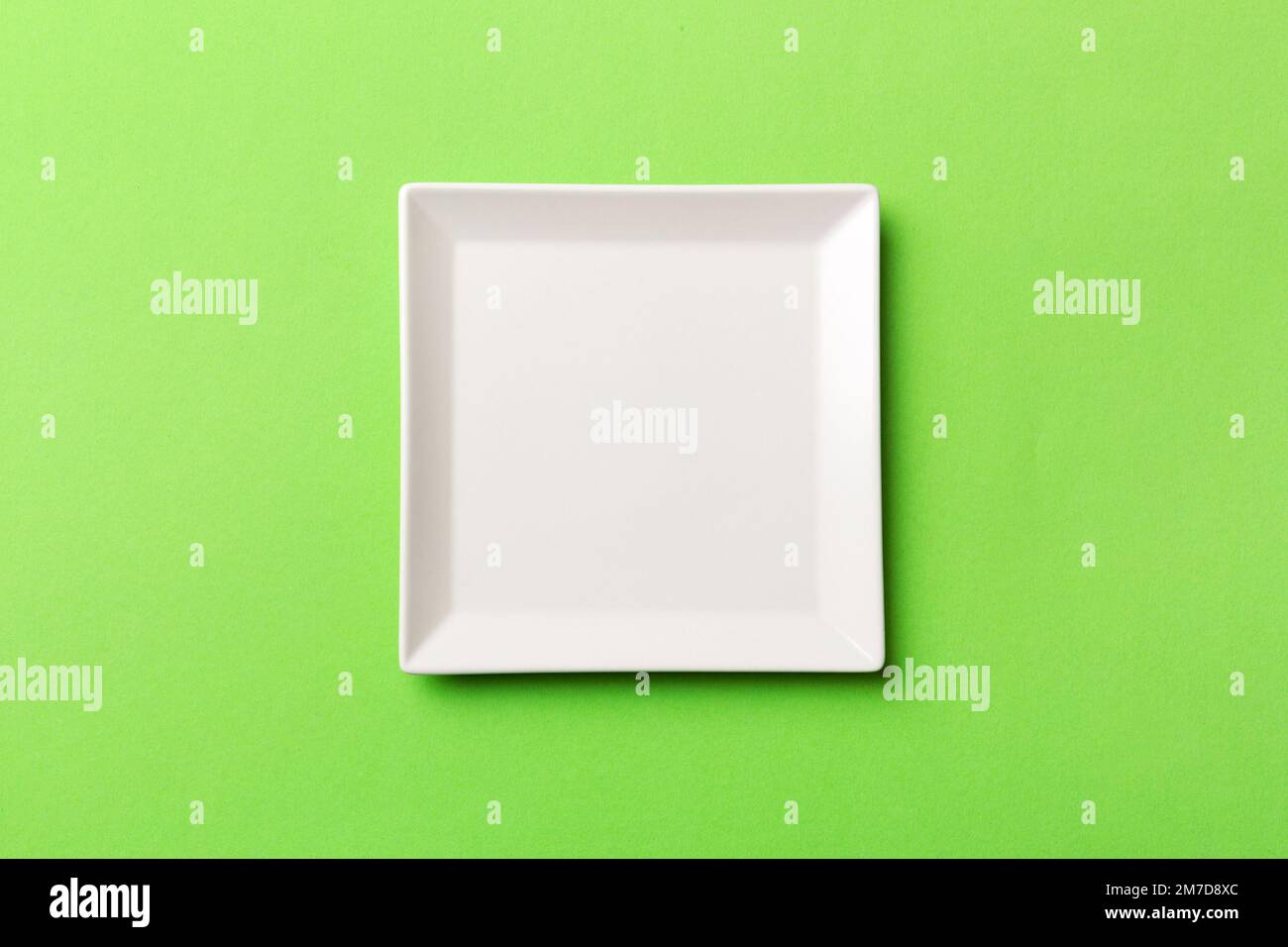 Top view of isolated of colored background empty square white plate for ...