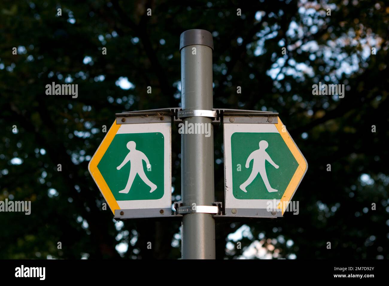 A signposted topped with two arrows indicating the direction of a ...