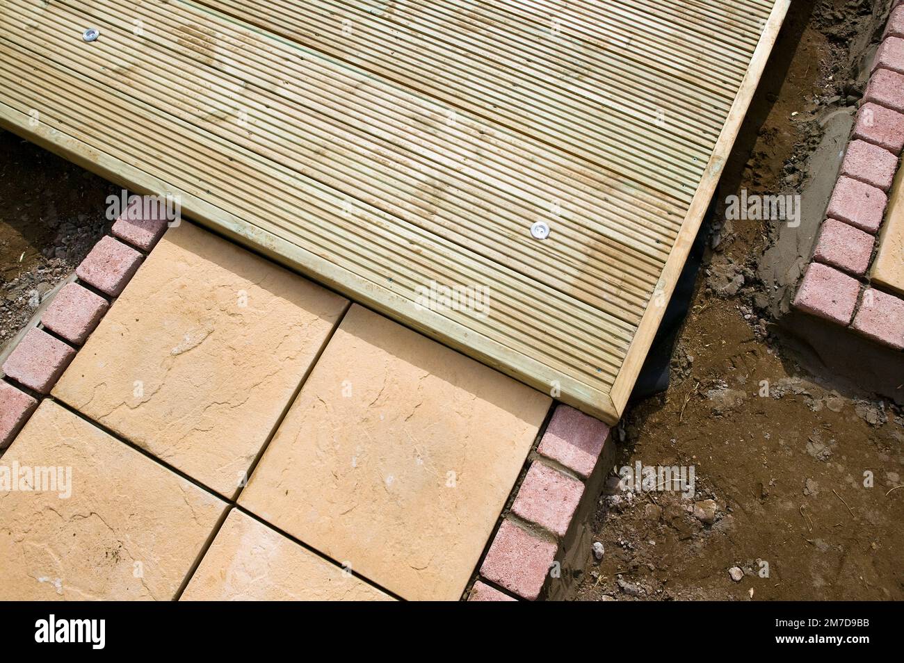 Preparing hard standing and decking areas in a small garden and laying ...