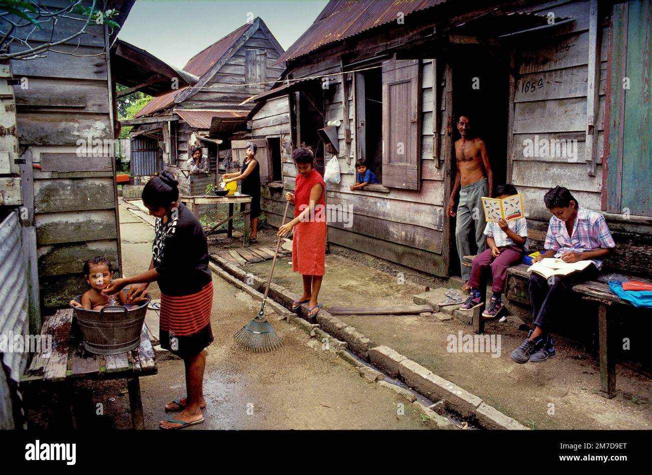 Surinam, families in a slum area in Paramaribo in front of their wooden ...