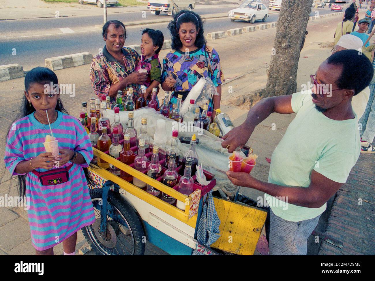 Surinam, Paramaribo. Man selling ice cream to a suri=nam family.This ...