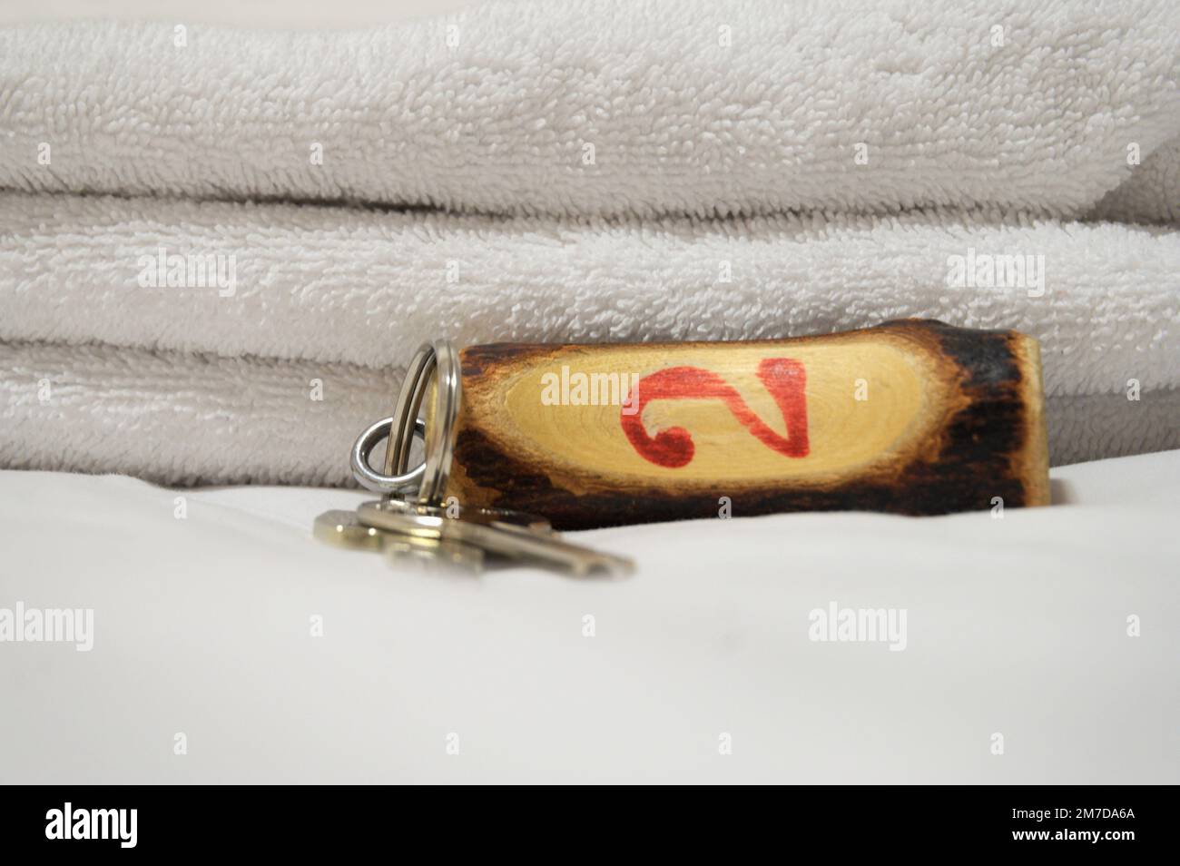 folded towels and hotel room key lying on bed Stock Photo - Alamy