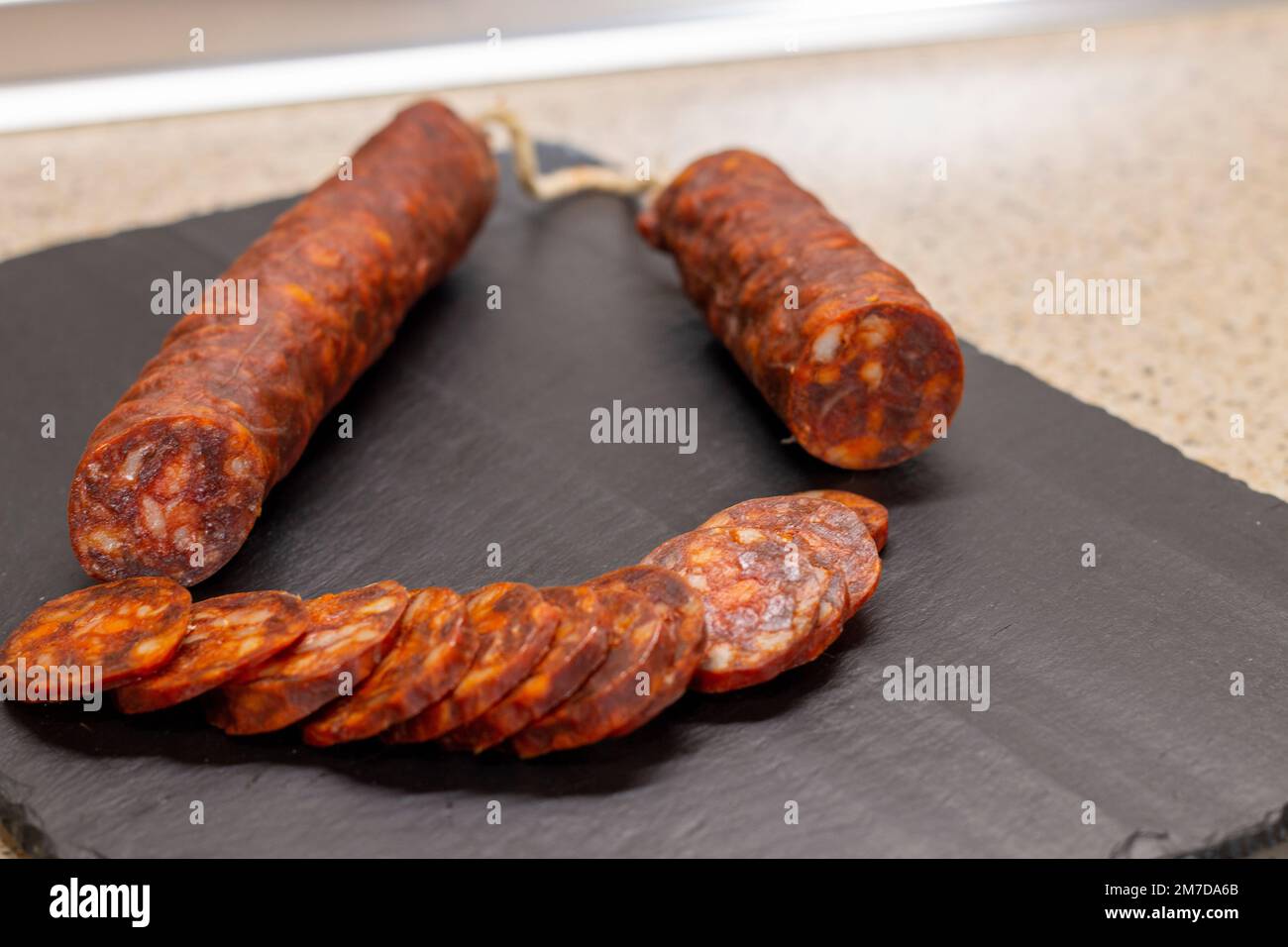 Authentic chorizo from León cut into thin slices, presented on a slate ...