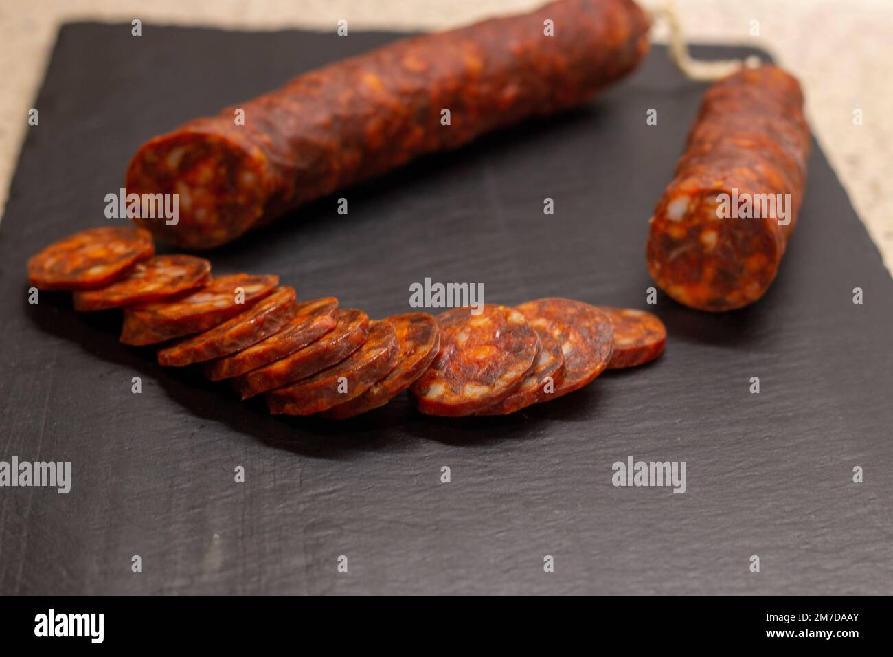 Authentic chorizo from León cut into thin slices, presented on a slate ...
