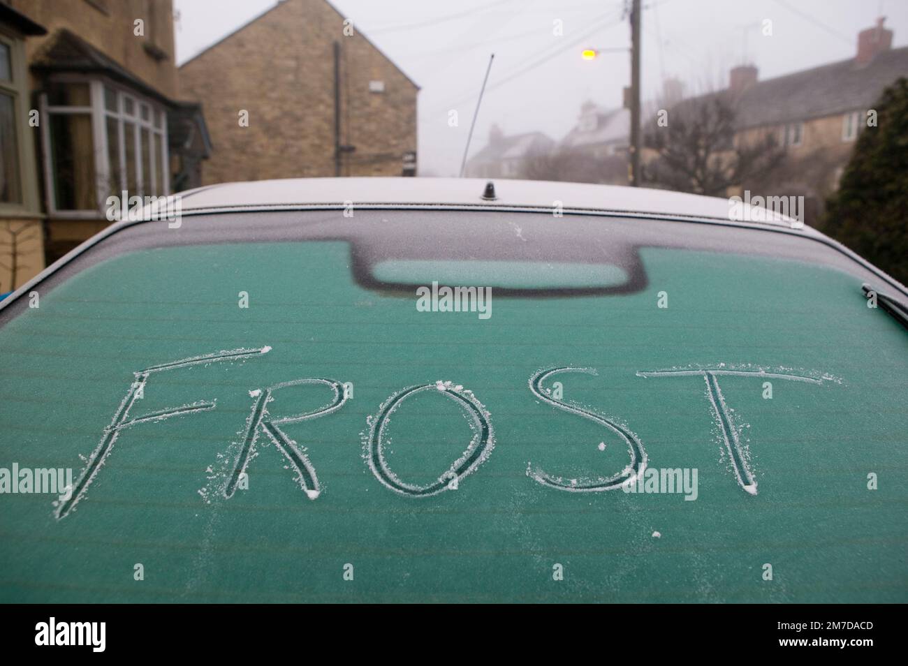 The word FROST scratched in the icy surface of a frosted over car ...