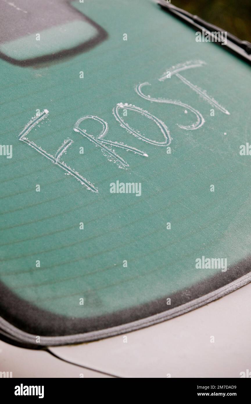 The word FROST scratched in the icy surface of a frosted over car ...