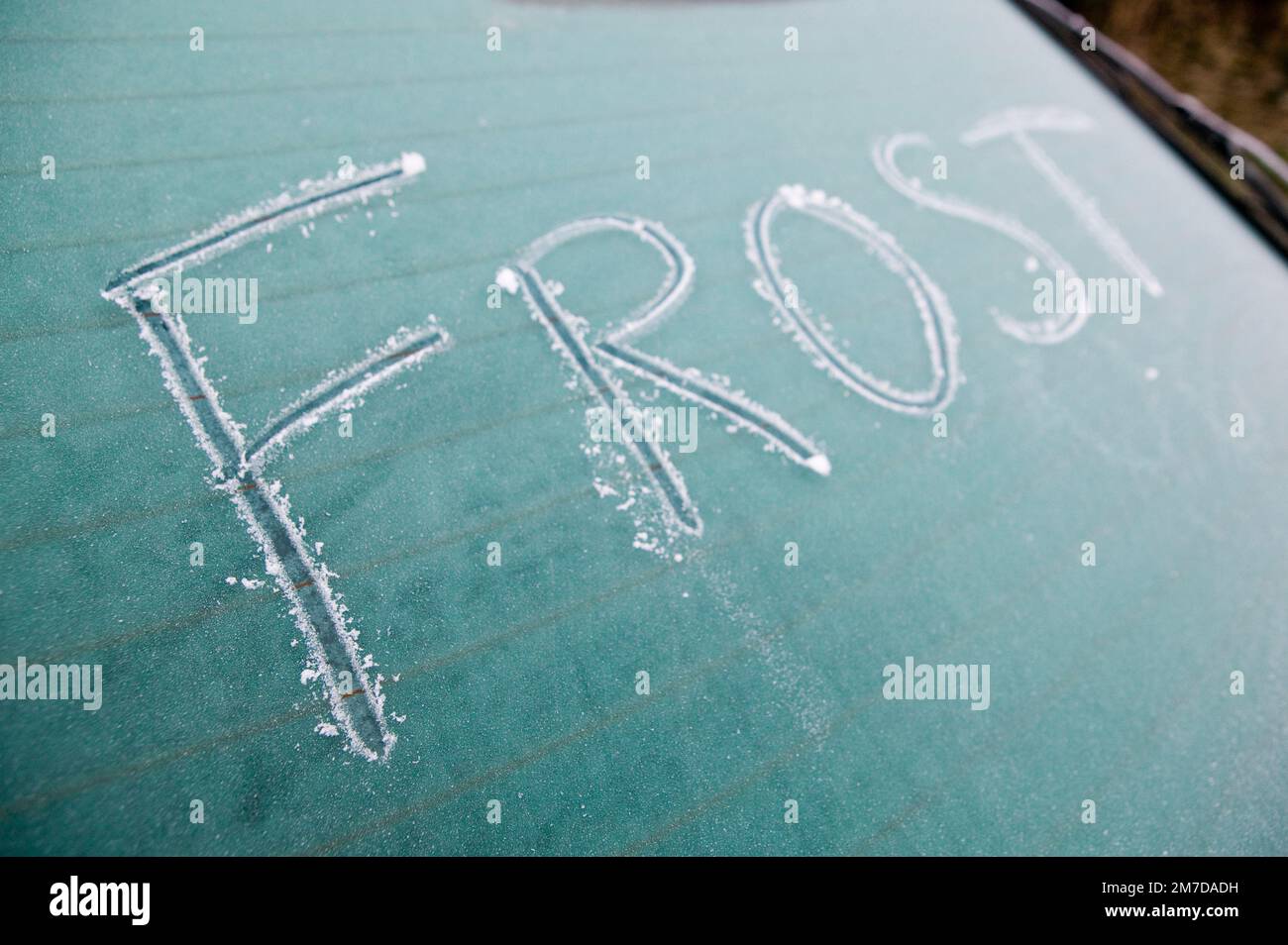 The word FROST scratched in the icy surface of a frosted over car ...