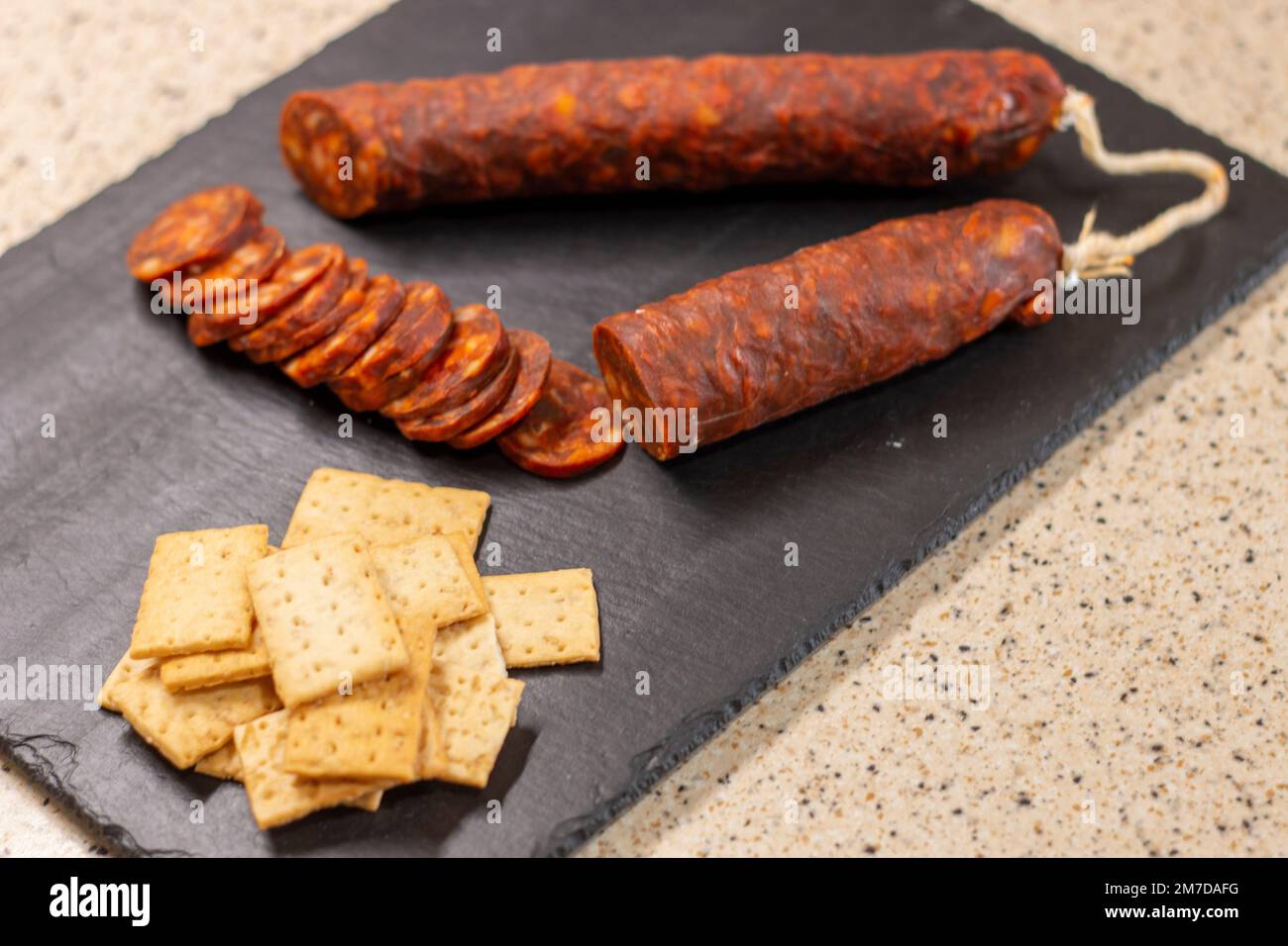Authentic chorizo from León cut into thin slices, presented on a slate ...