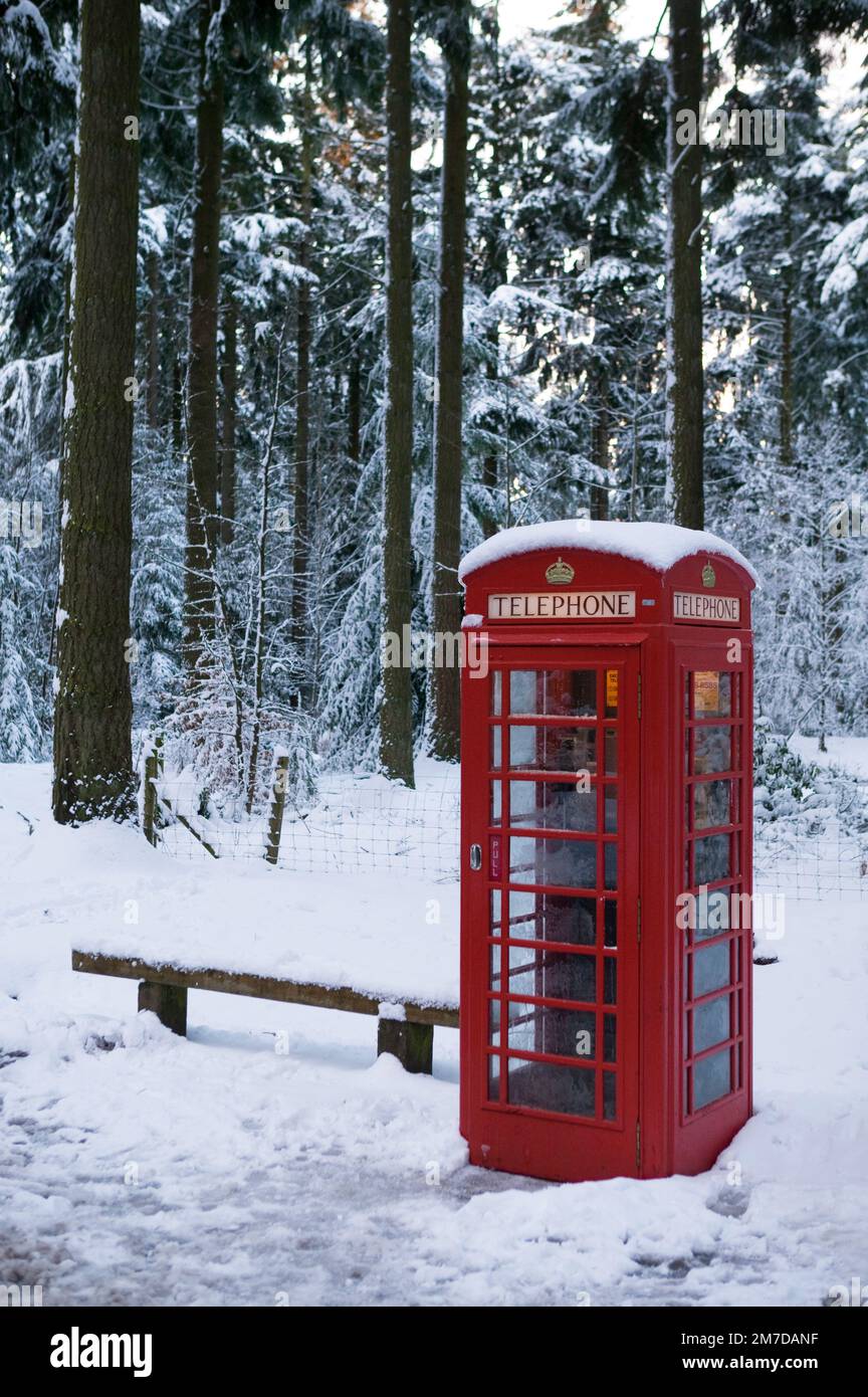 An old british red telephone box stands alone in a snowy landscape ...