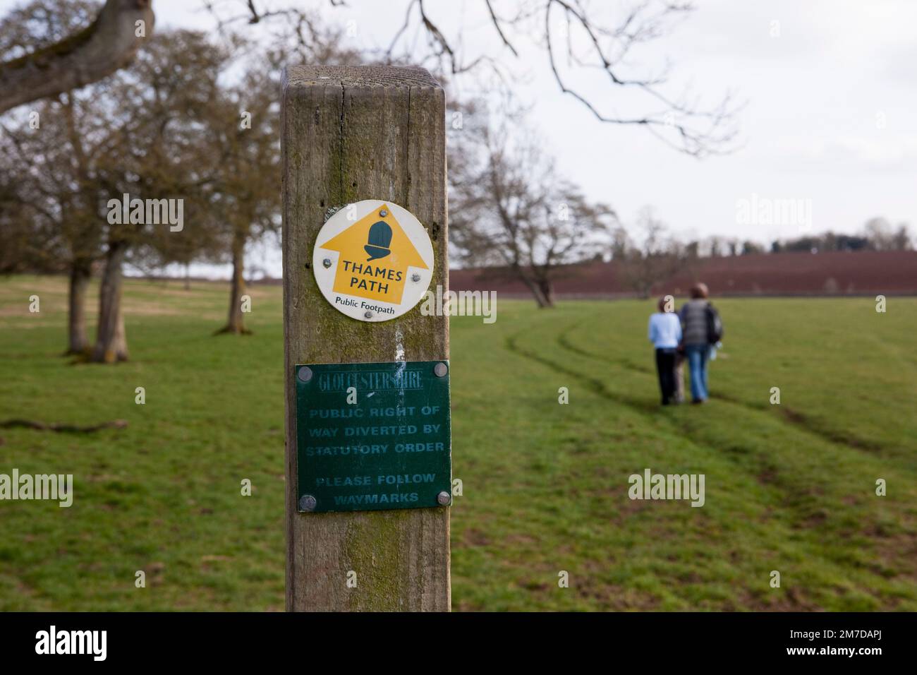 Signs on a post indicating the direction of the pathway along "the ...