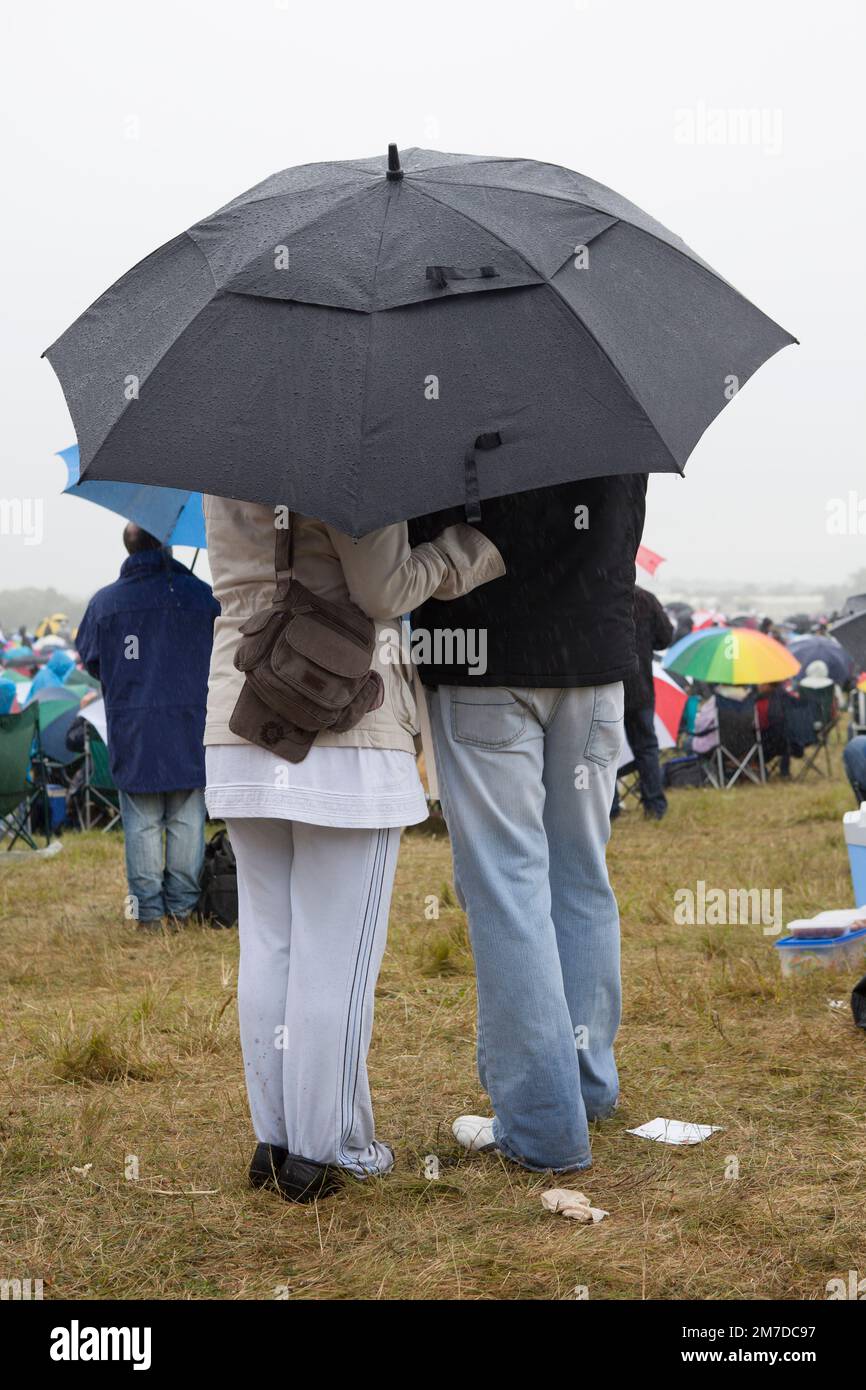 A couple hug and cuddle close together for warmth as they take cover ...