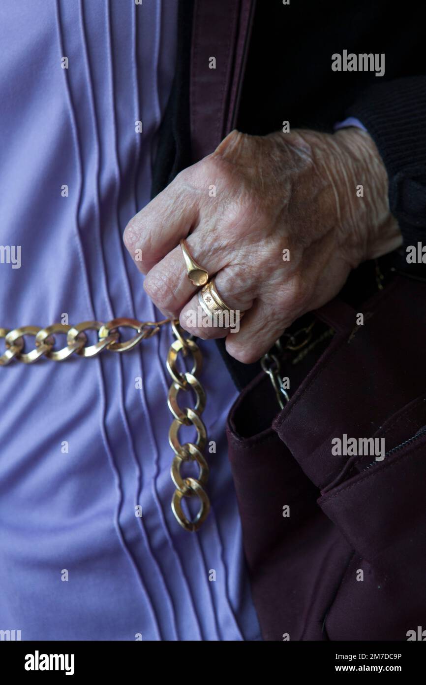 Detail of the hand and clothing of an octagenarian woman, showing her ...