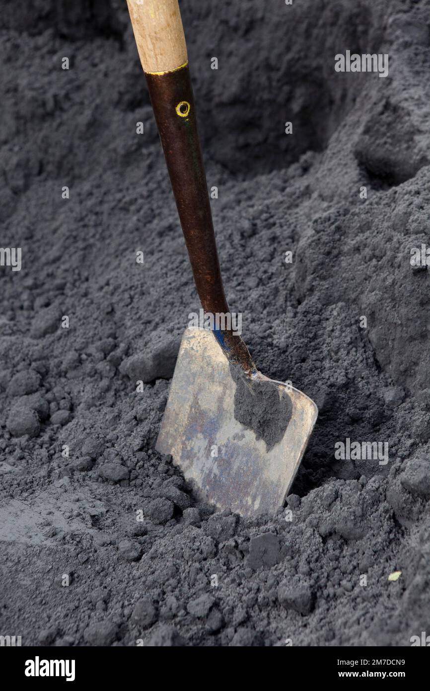 A garden spade set in to a pile of Ash or clinker Stock Photo - Alamy