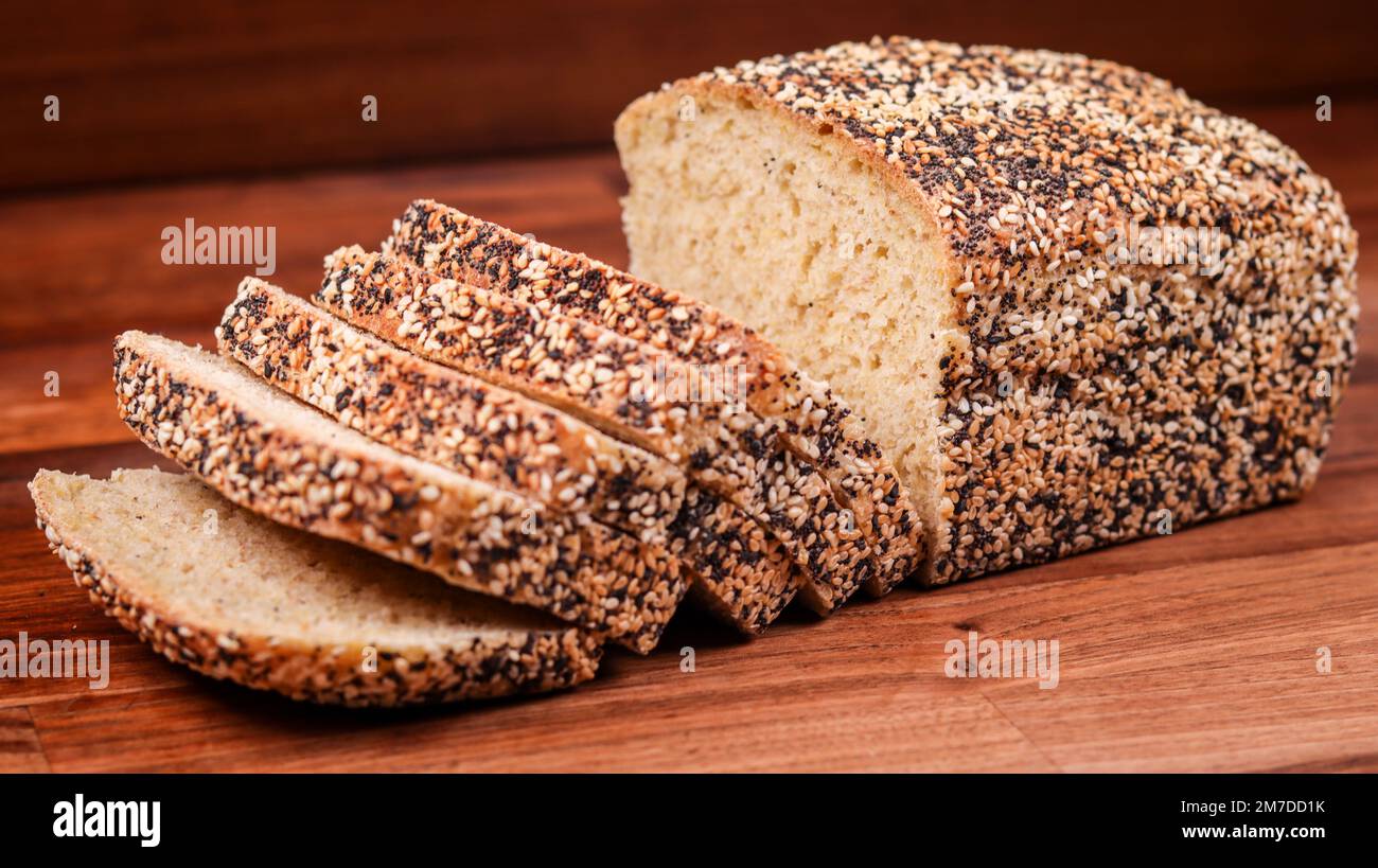 A closeup shot of a Multigrain bread sliced on a wooden board on an ...