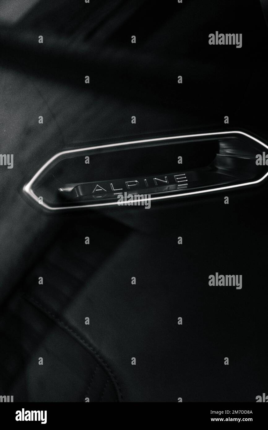 A vertical closeup shot of the logo of the Alpine car brand on the ...