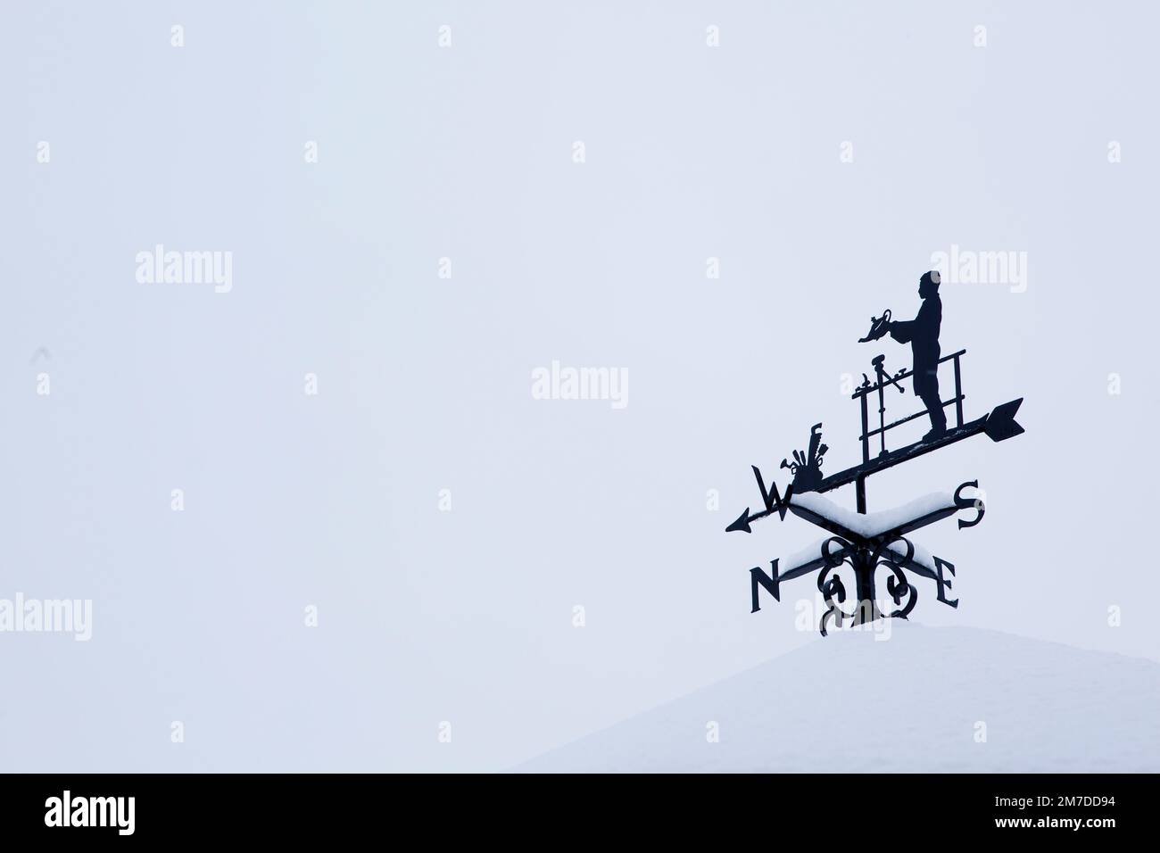 Weather vein in a winters sky with snow covered roof Stock Photo - Alamy