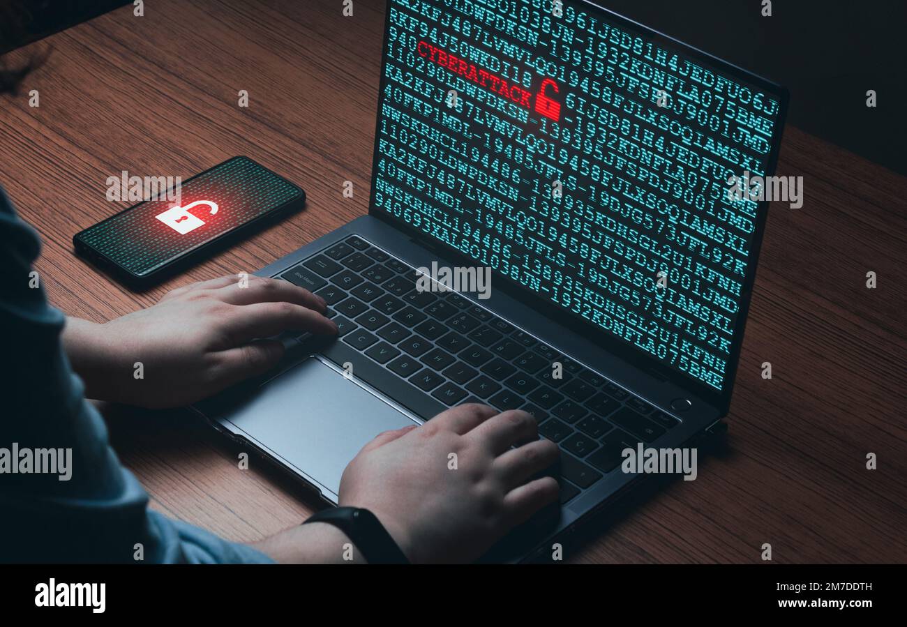 Woman using laptop on wood desk with cyberattack warning on screen ...