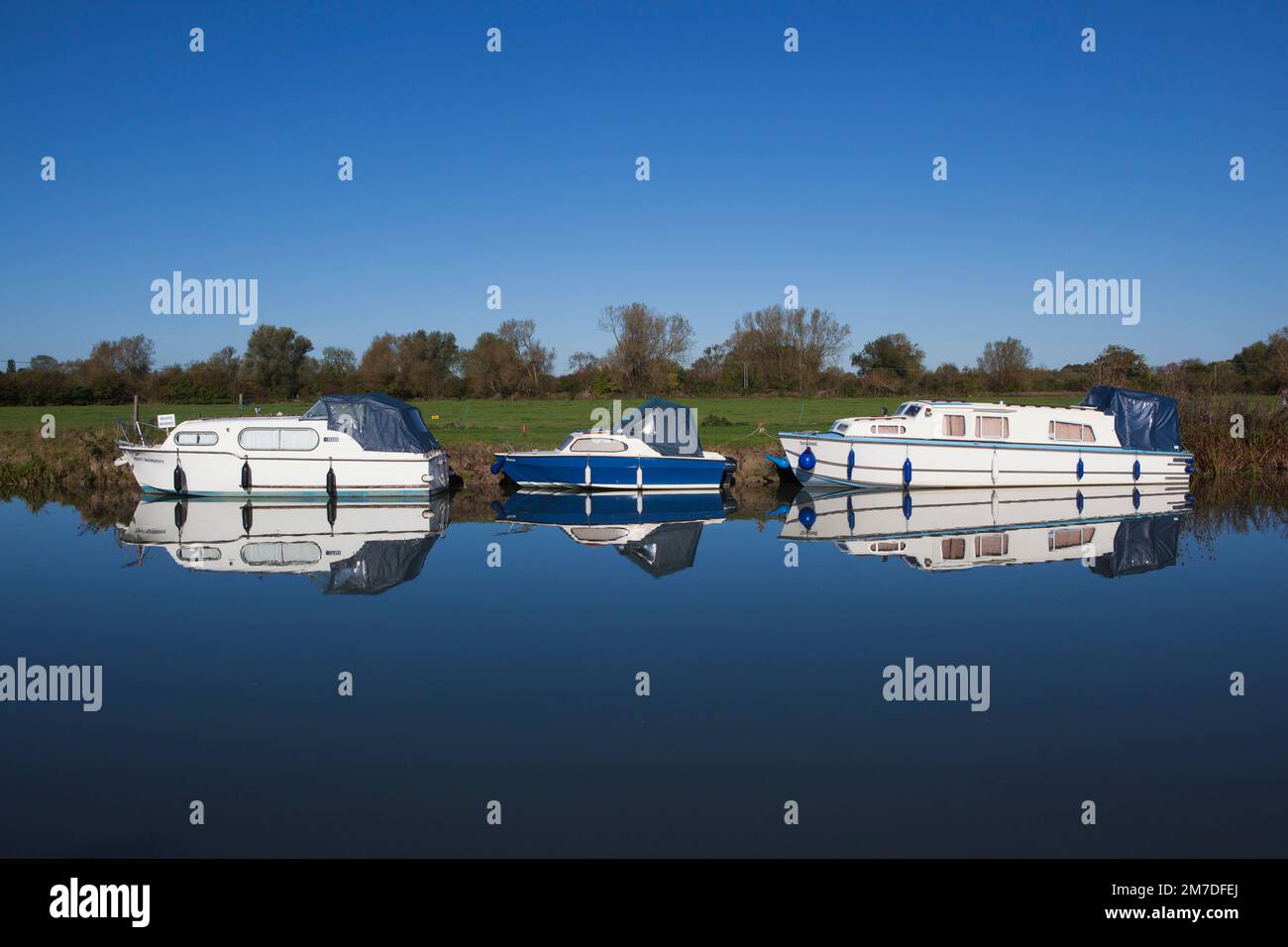Small boats moored along the river Thames at Lechlade, with their image ...