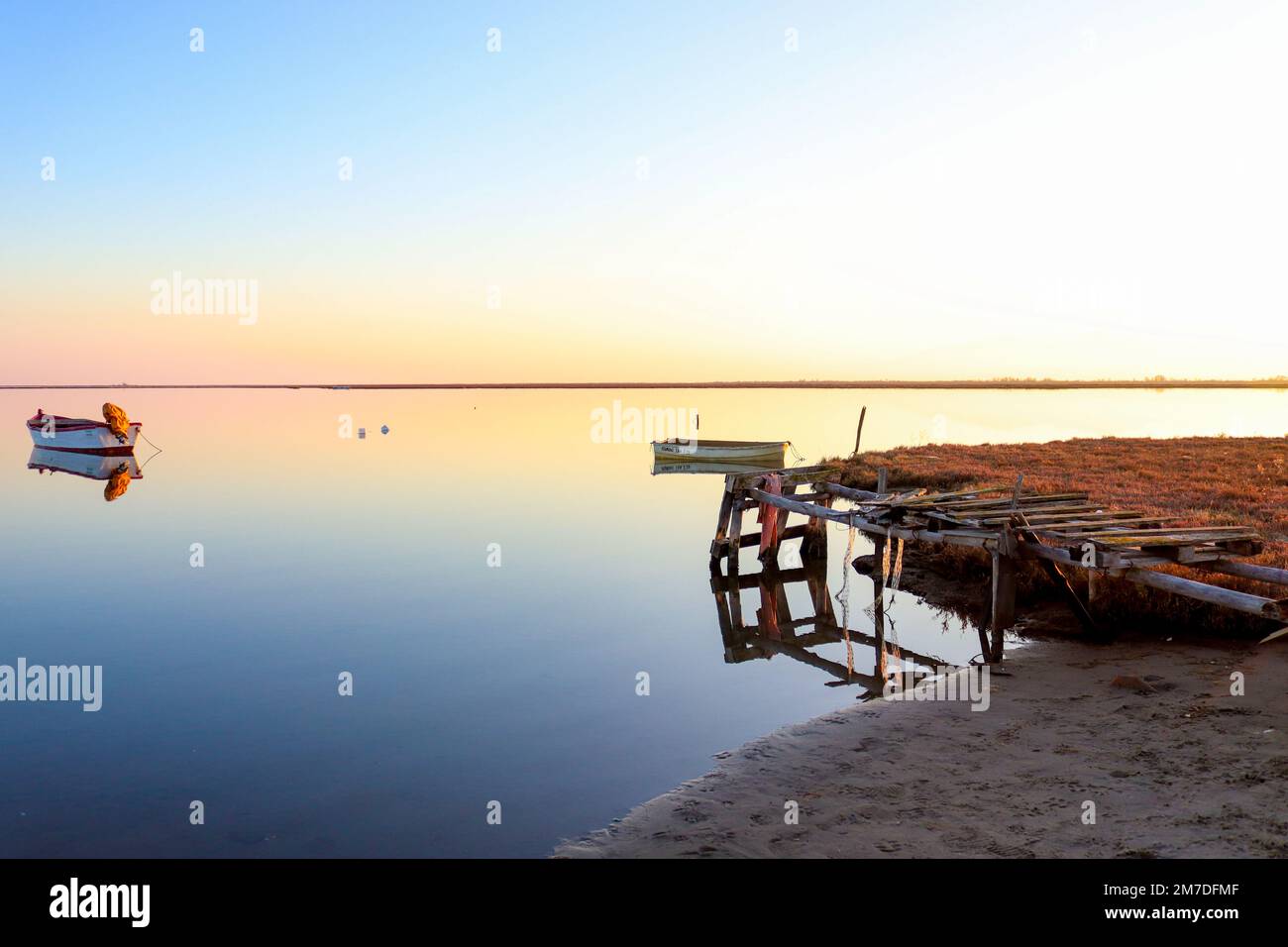 fishing boats sailing,view from an old pier at sunset Stock Photo - Alamy