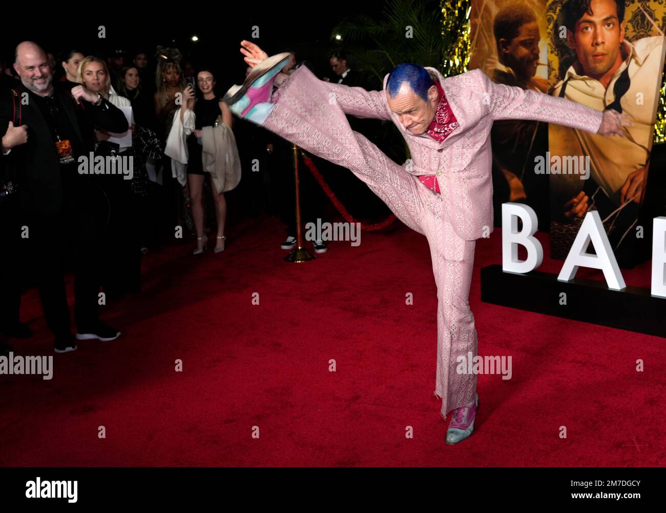 Flea, a cast member in "Babylon," performs a kick for photographers at ...