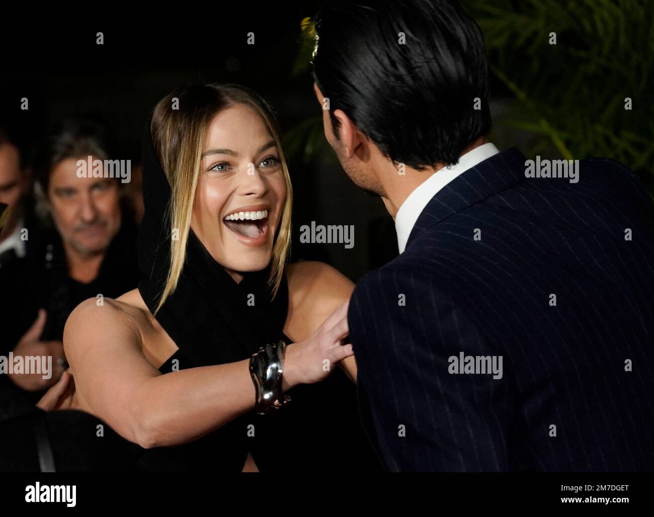 Margot Robbie, left, a cast member in "Babylon," greets fellow cast ...