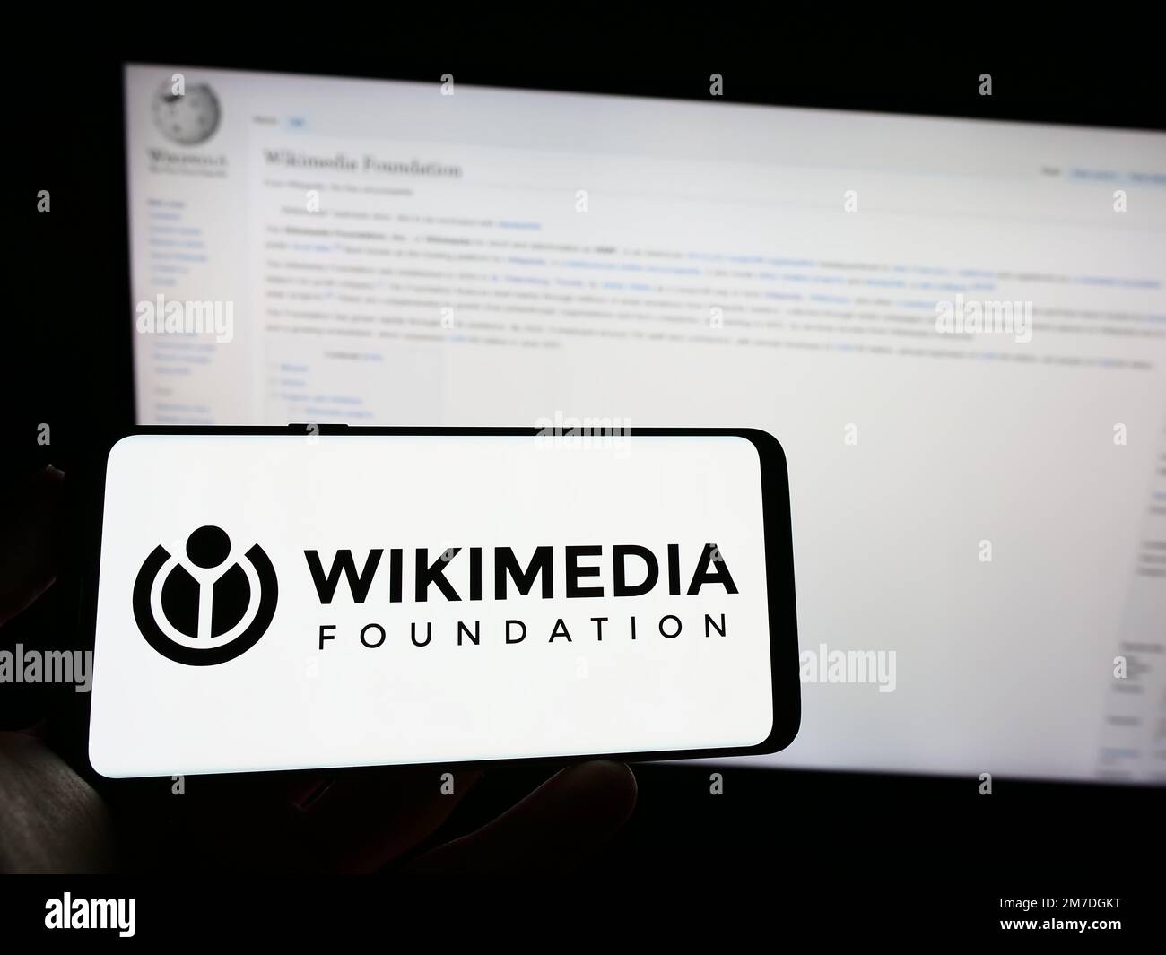 Person holding mobile phone with logo of Wikimedia Foundation Inc. on ...