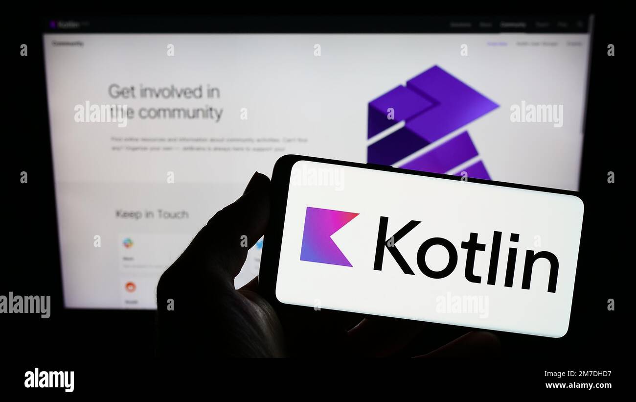 Person holding smartphone with logo of programming language Kotlin on ...
