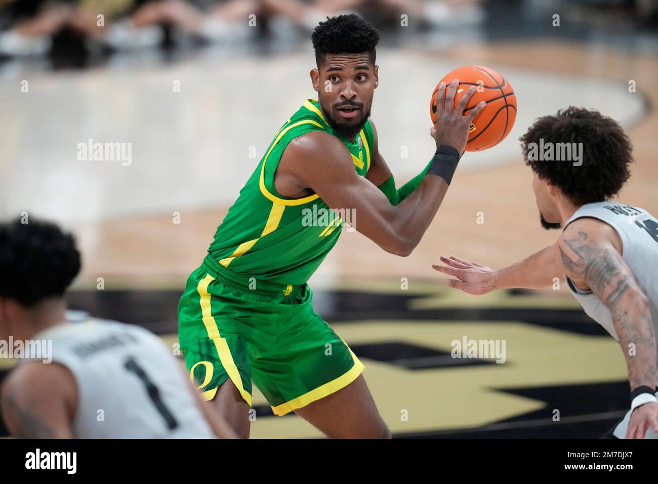 Oregon forward Quincy Guerrier, center, looks to pass the ball as ...