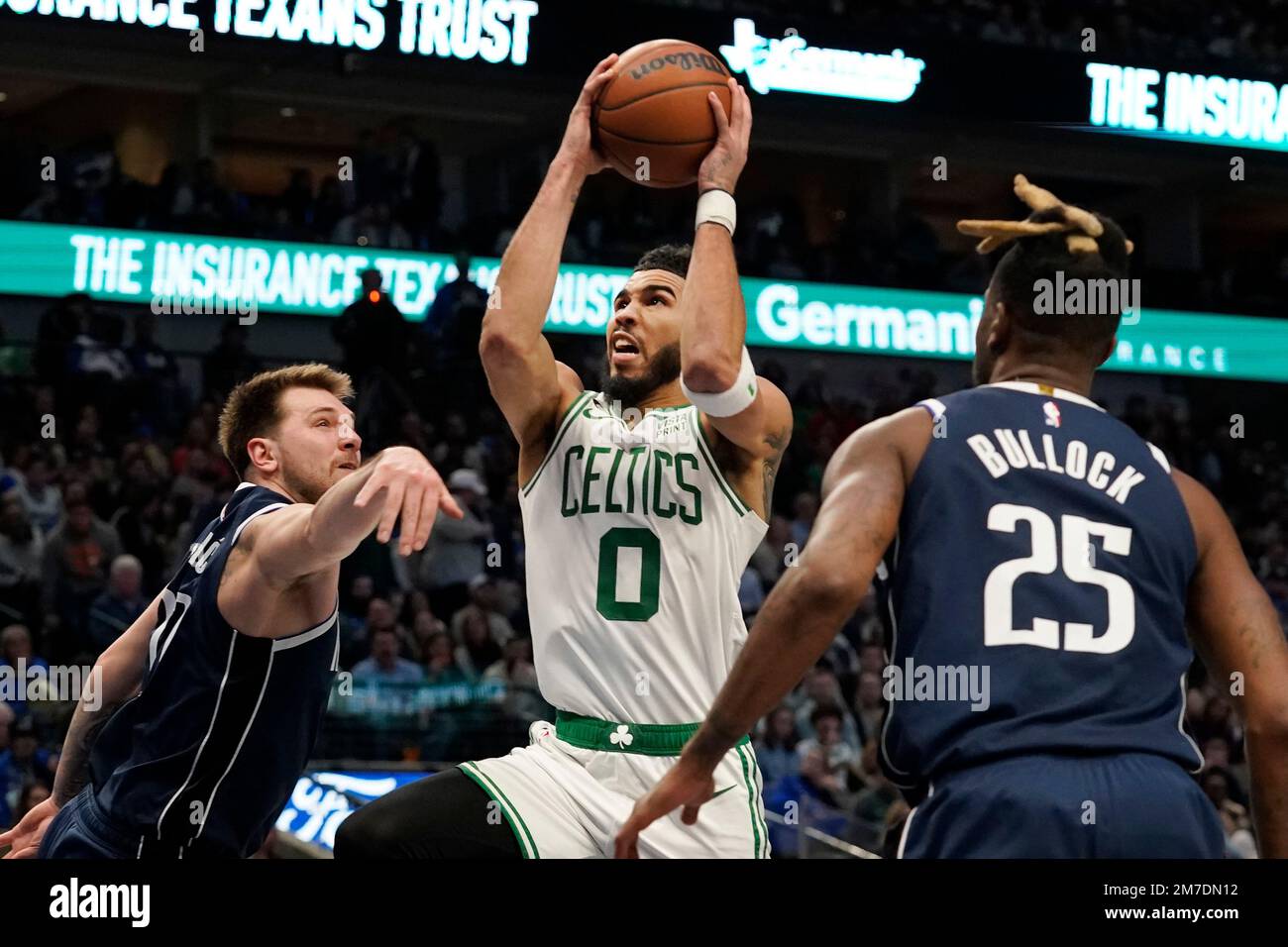Boston Celtics forward Jayson Tatum (0) drives between Dallas Mavericks ...