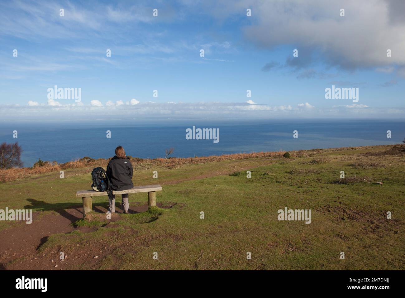 A walker takes a rest overlooking the coast out to sea on her route ...