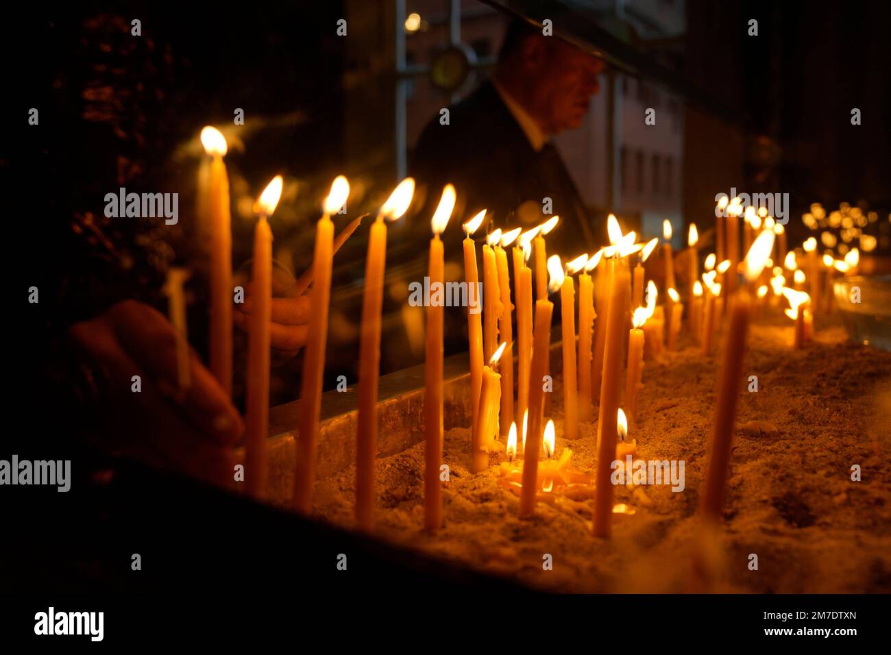 Orthodox Christian faithfuls light candles during the Epiphany Mass at ...
