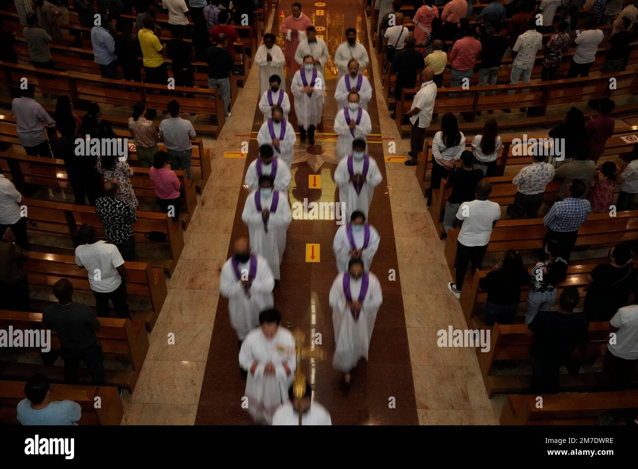 People stand as the priest leaves after a liturgy at the Catholic ...