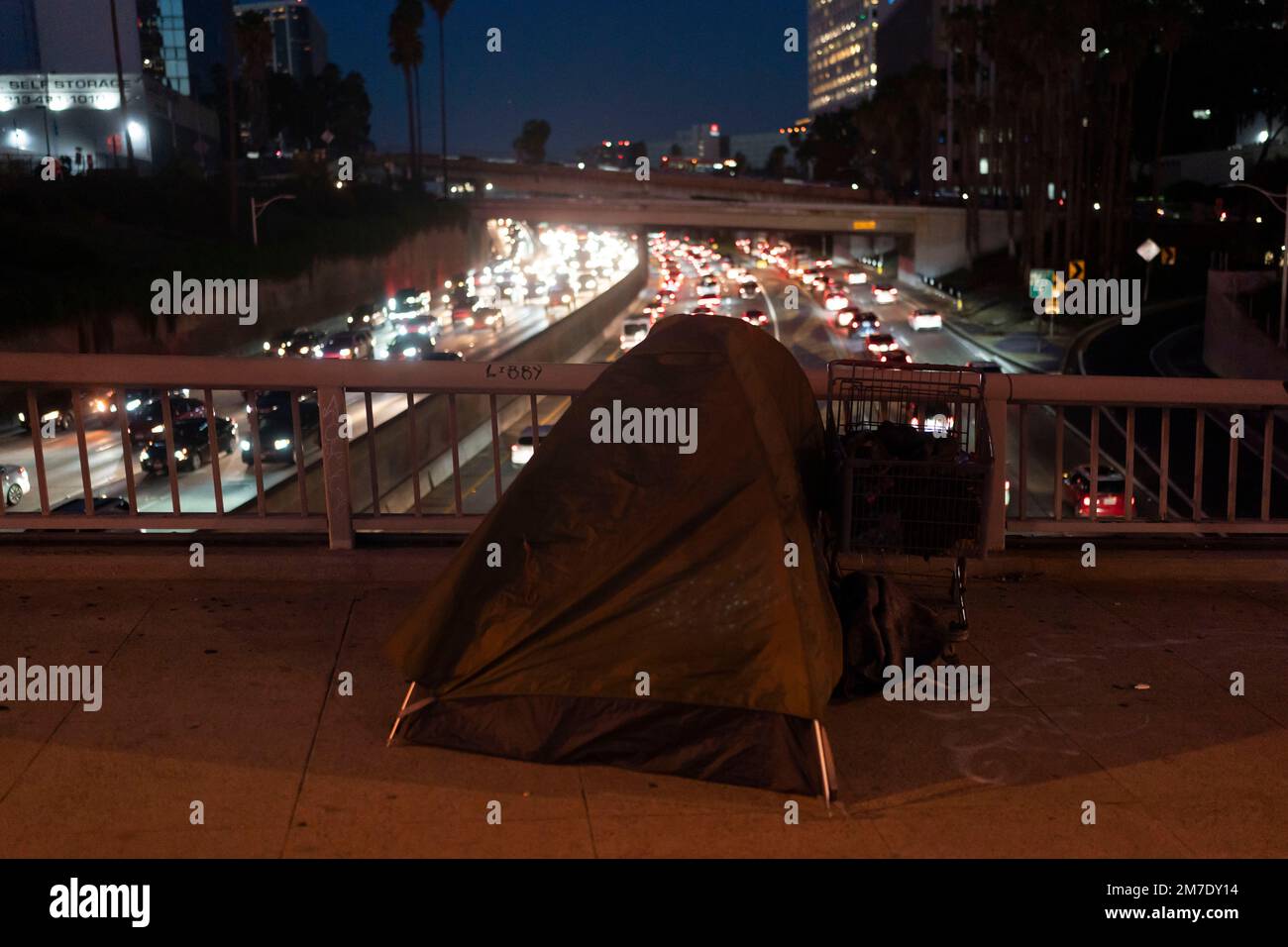 A homeless person's tent sits on a bridge over the 110 Freeway in Los ...