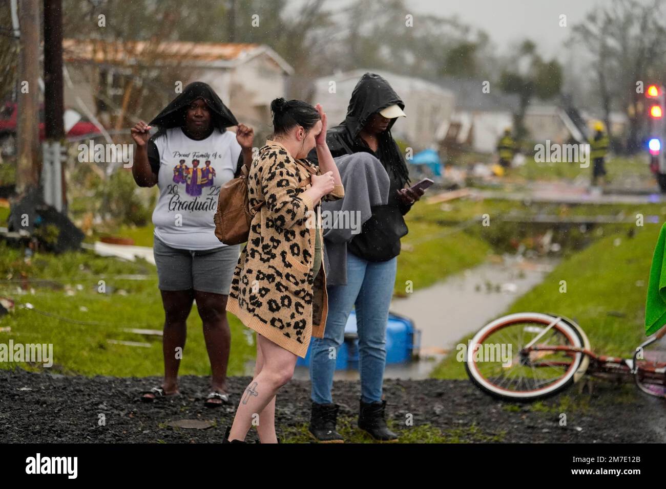 Residents stand outside destroyed homes from a tornado that tore ...