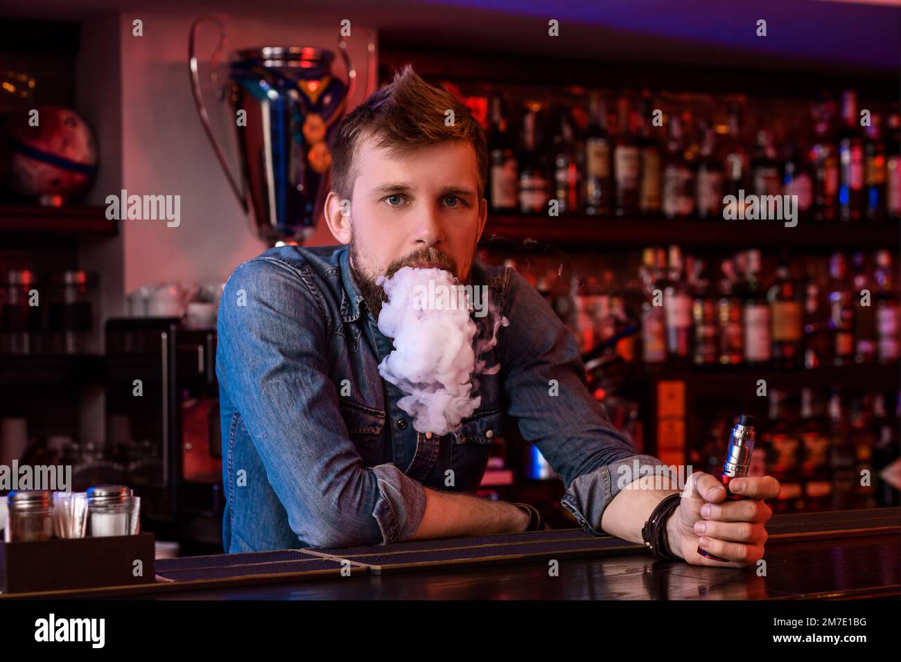 Vape. Vaping man in a cloud of vapor. Photo is taken in a vape bar ...