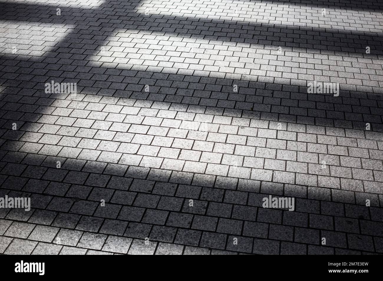 Shadow patterns cast across a tiled paved concrete pavement Stock Photo ...