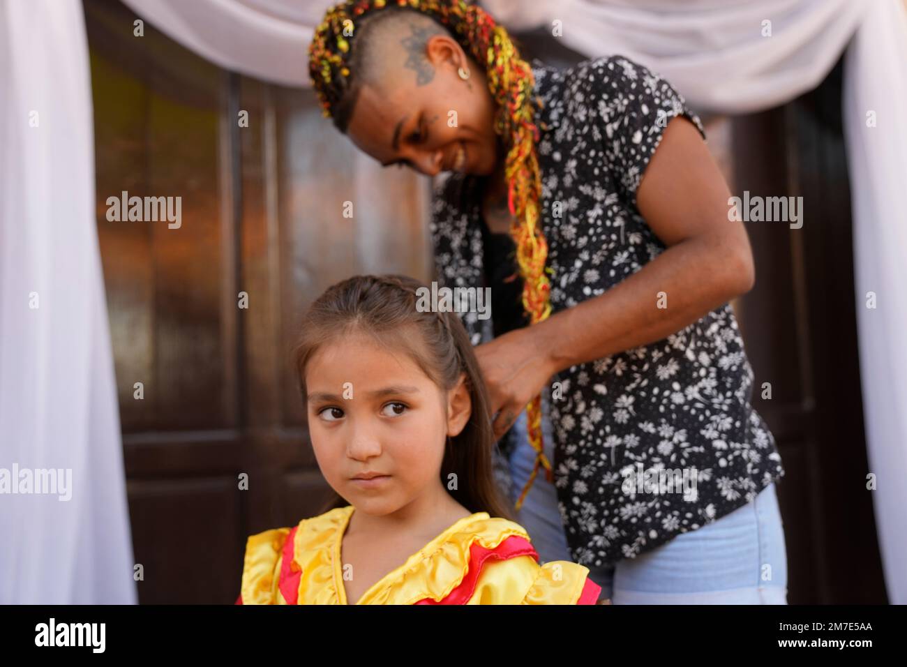 Cristina Flores styles the hair of Valentina Espinos, both members of ...