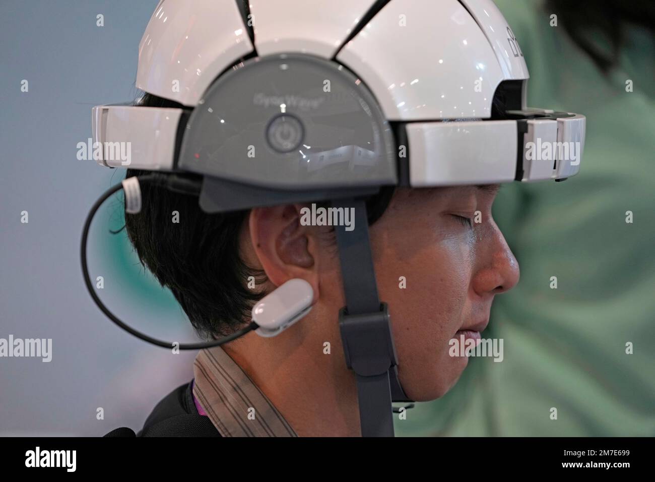 A CES attendee wears an iSync Wave EEG helmet at the iMediSync booth ...